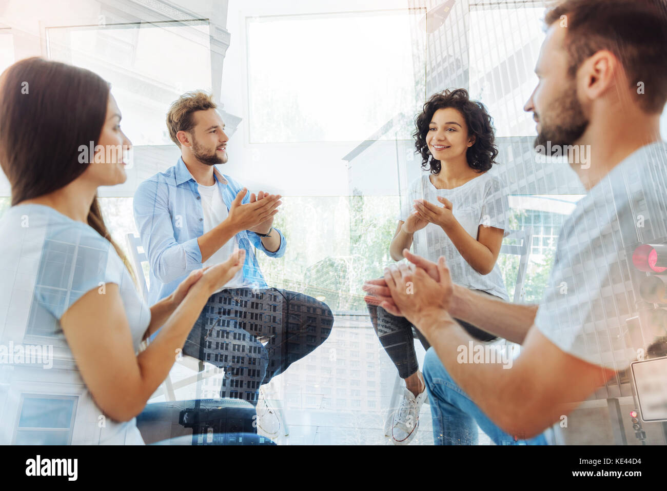 Happy friends clapping hands together Stock Photo - Alamy