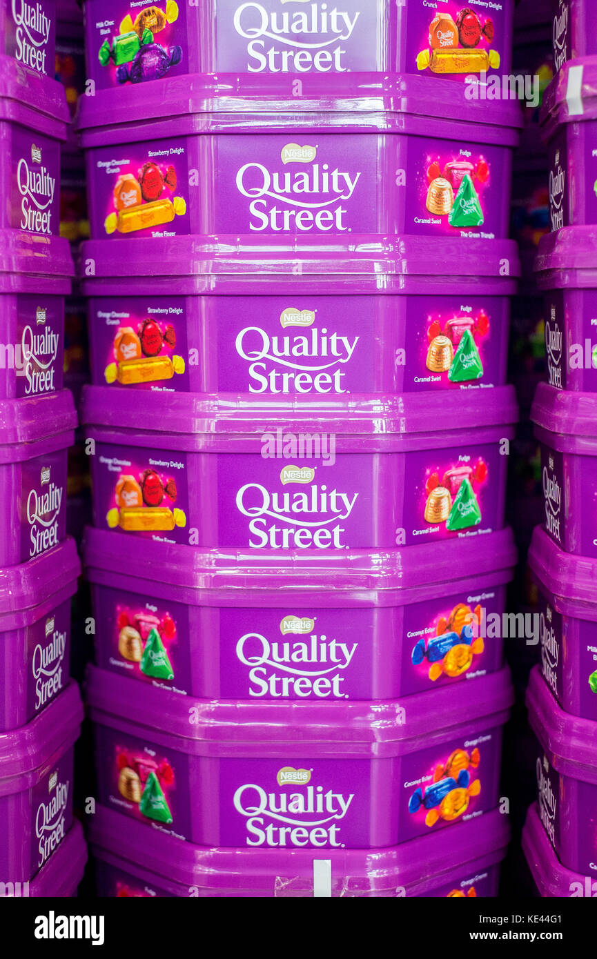 Tins of Quality Street Chocolates stacked own the shelf in a UK ...