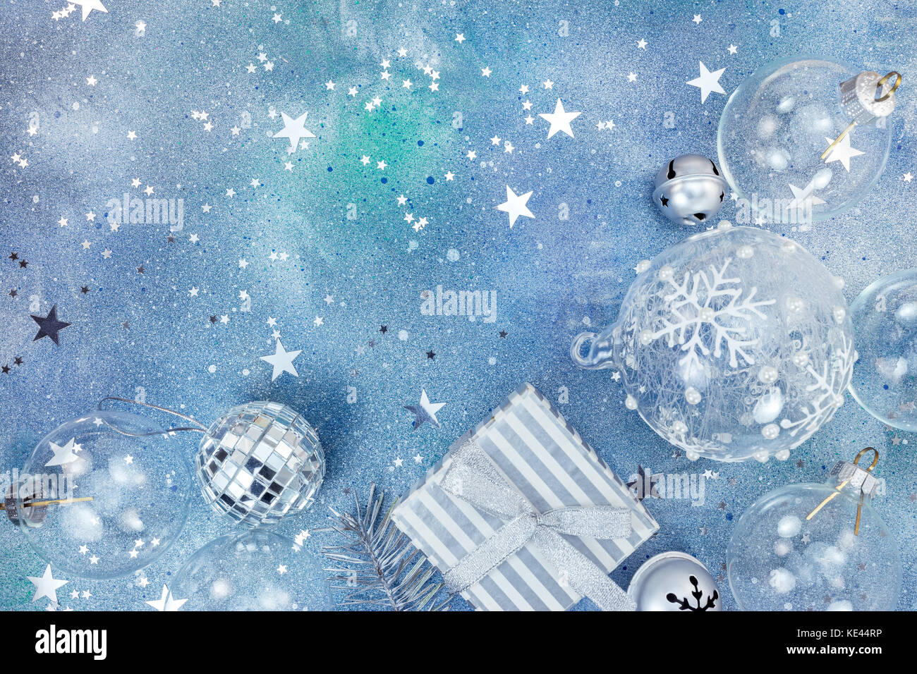 christmas gift box among glass balls and silver jingle bells on starry ...