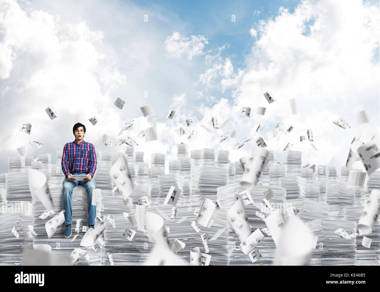 Attractive man sitting on pile of paper documents Stock Photo - Alamy