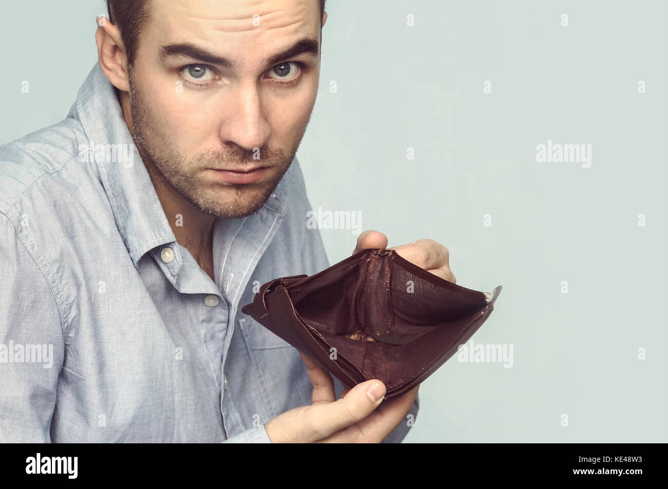 Bussinessman holding an empty wallet in his hands. The guy shows the ...