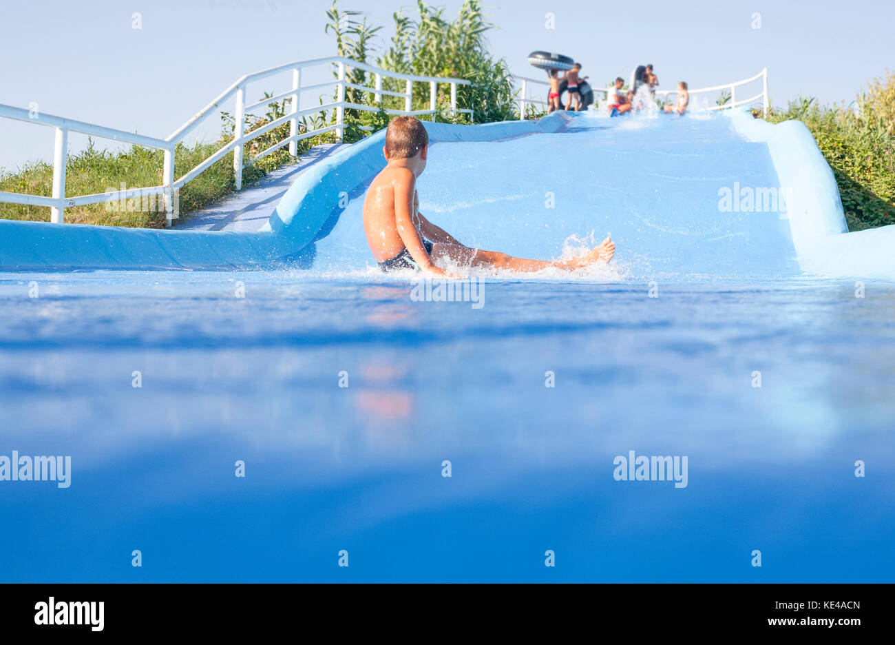 Child playing on water slide hi-res stock photography and images - Alamy