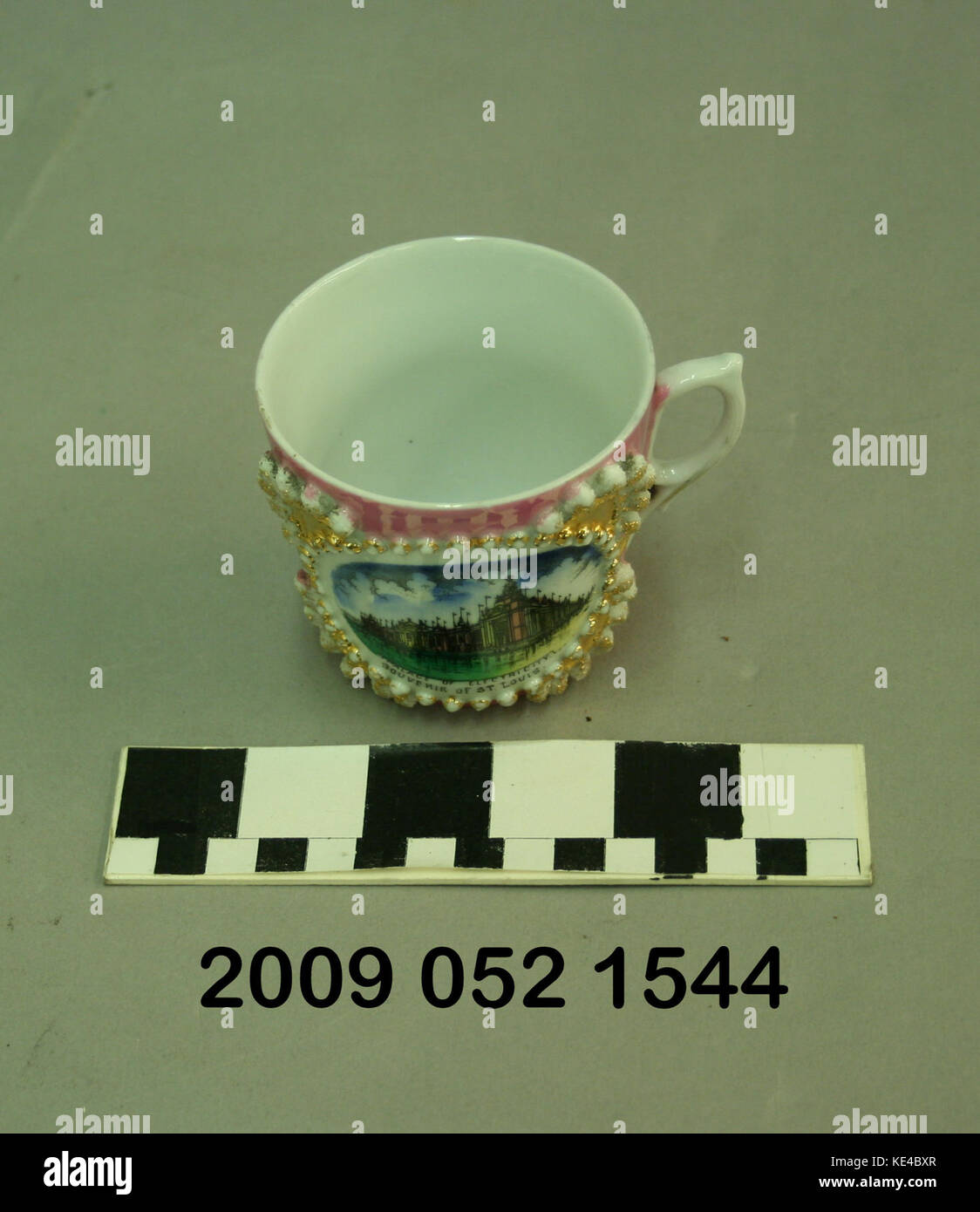 This white ceramic teacup, decorated in pink, features a color transfer ...