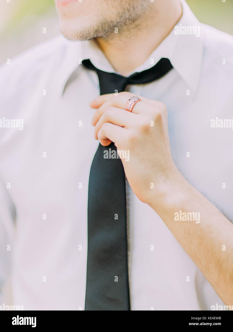 The hands of the man are correcting the black tie Stock Photo - Alamy