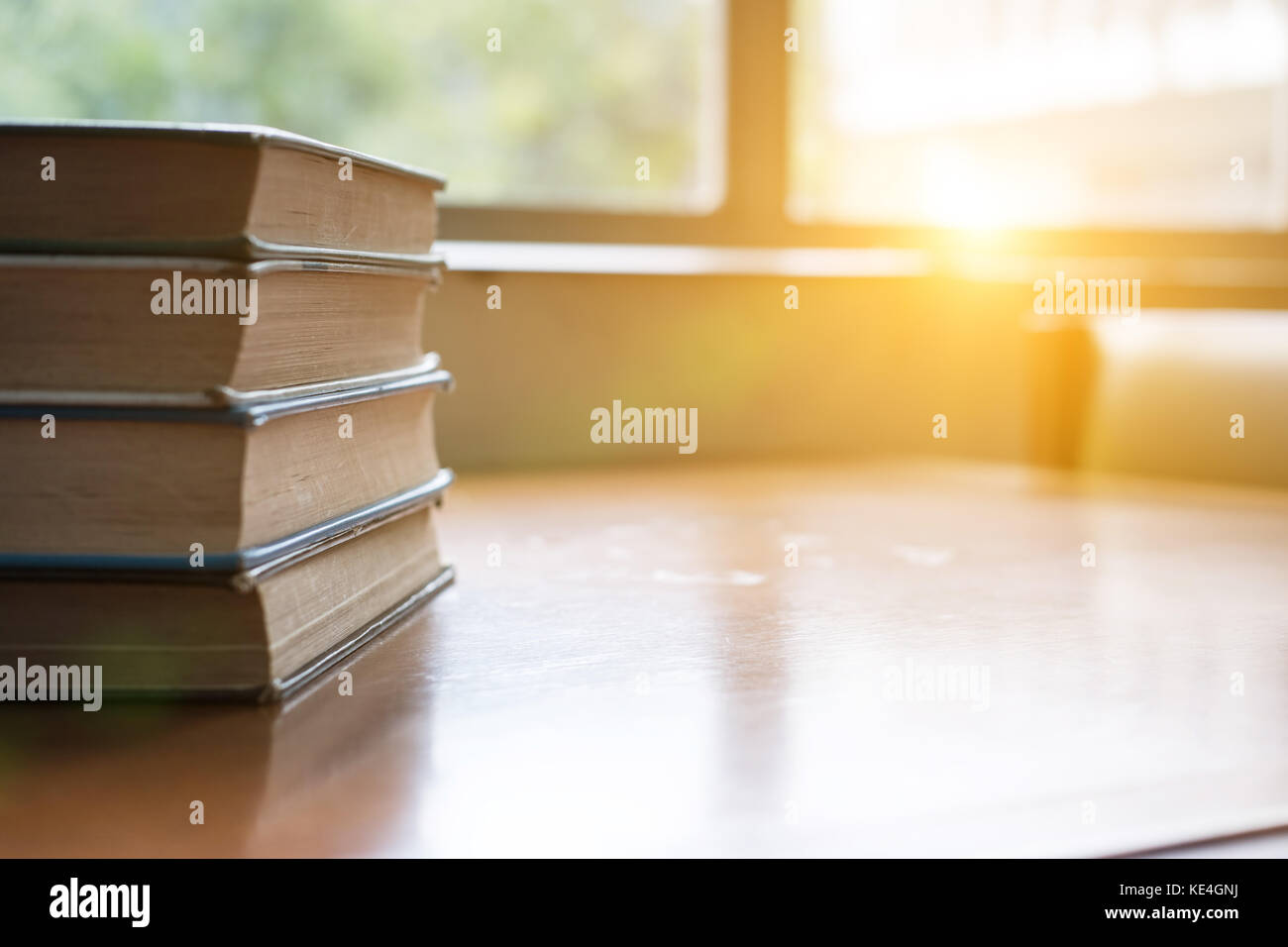 old book on wood table. textbook beside window. education, study ...