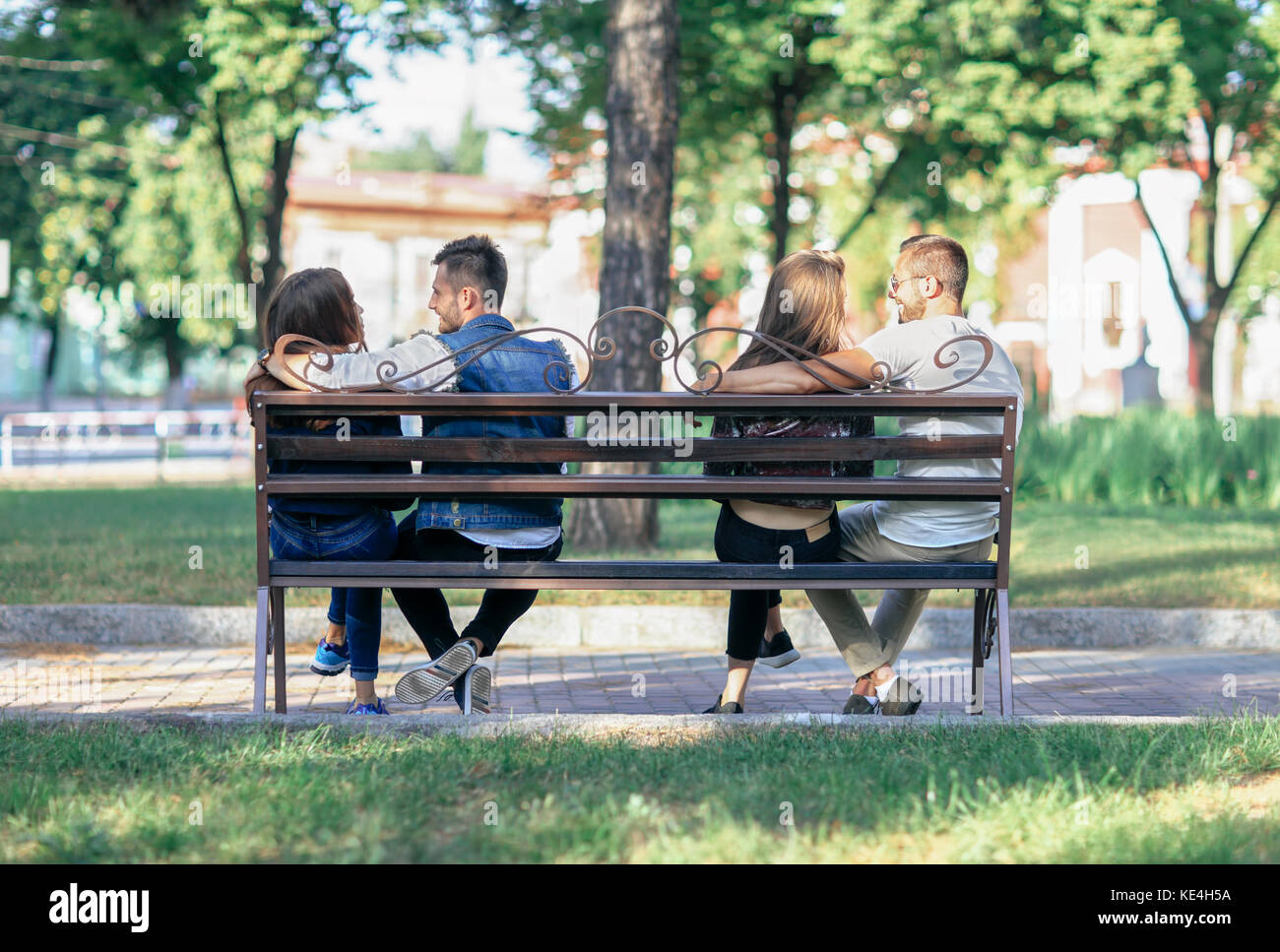 Two Lovers Couples Sitting On Different Ends Of One Bench Young Happy
