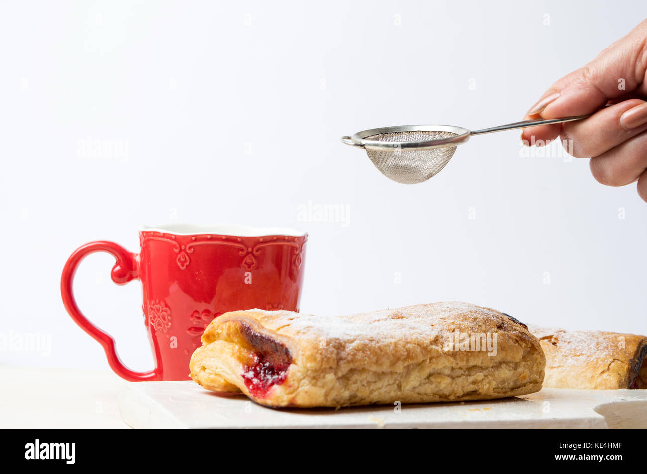 Female hand adding sugar to puff pastry against white background Stock ...