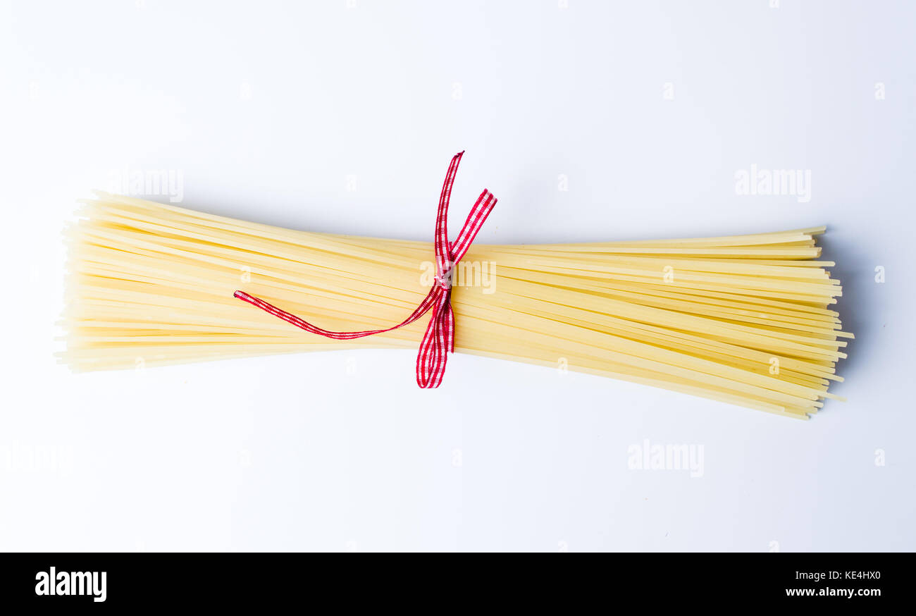 Uncooked spaghetti tied with a rope isolated on white Stock Photo - Alamy