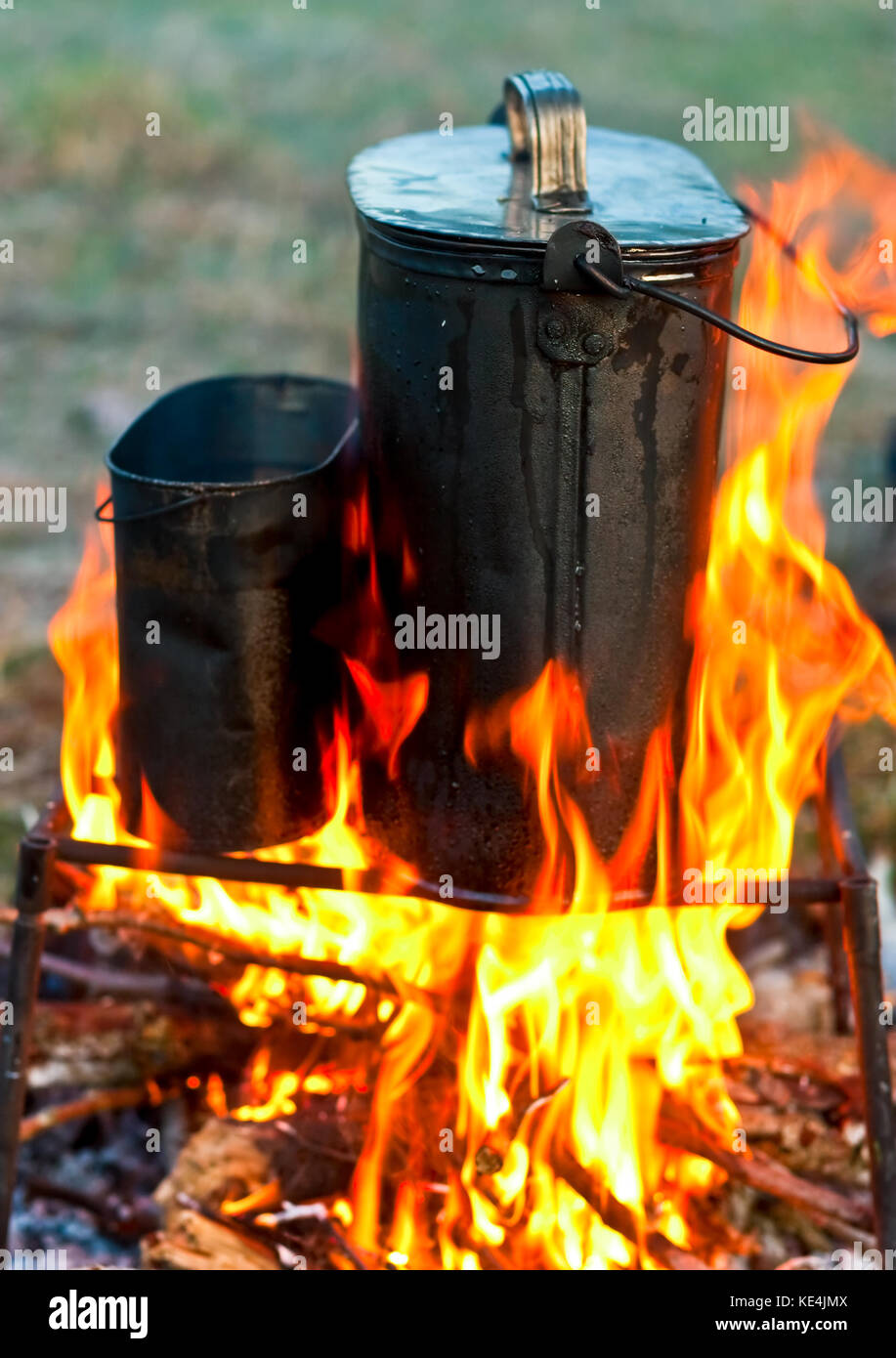 Two camping kettles over burning campfire Stock Photo - Alamy