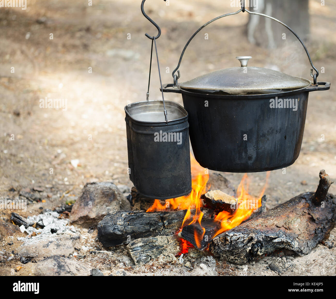 Cauldrons over burning campfire Stock Photo - Alamy