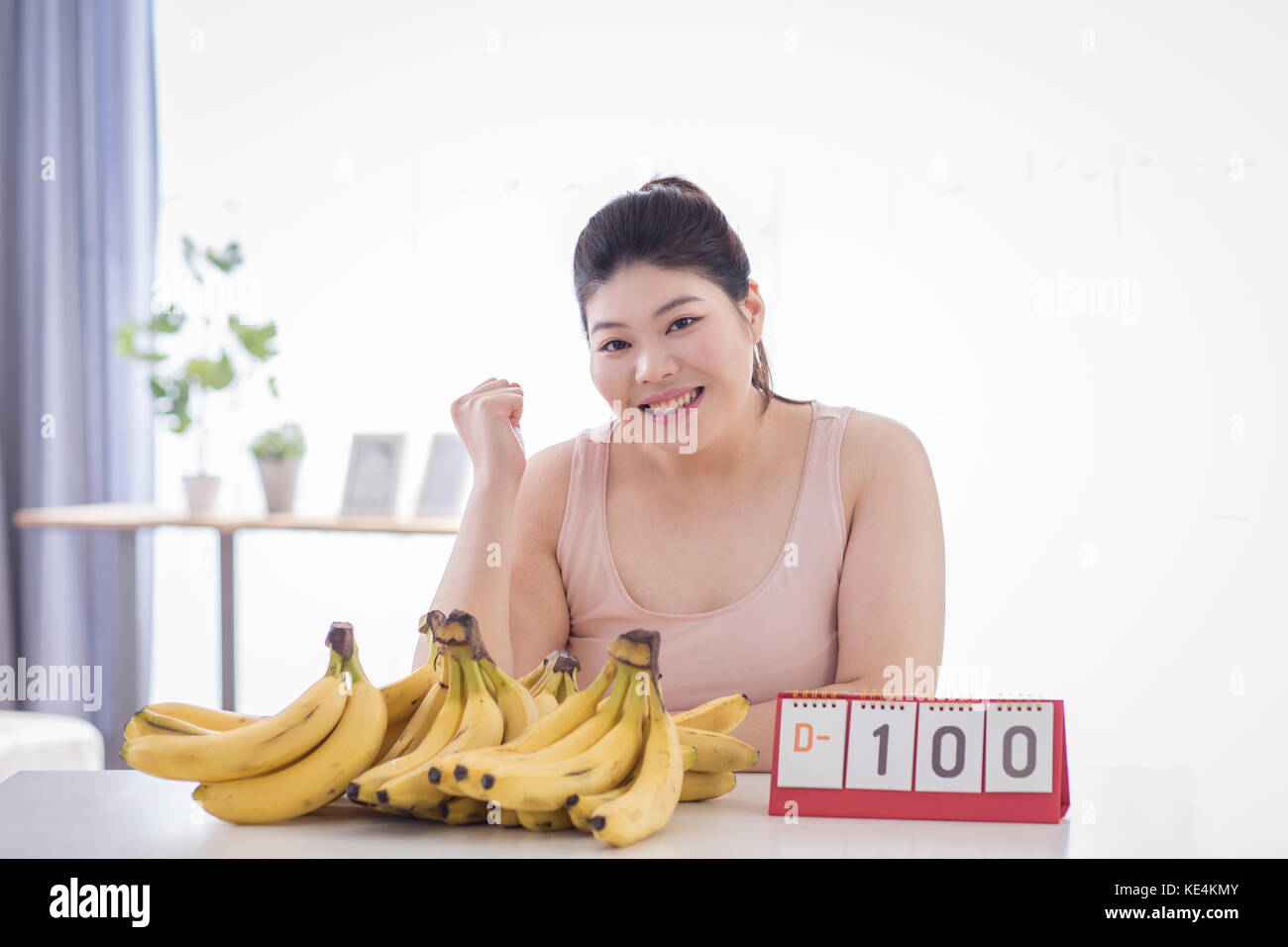 Portrait of young smiling fat woman with bananas and calendar Stock ...