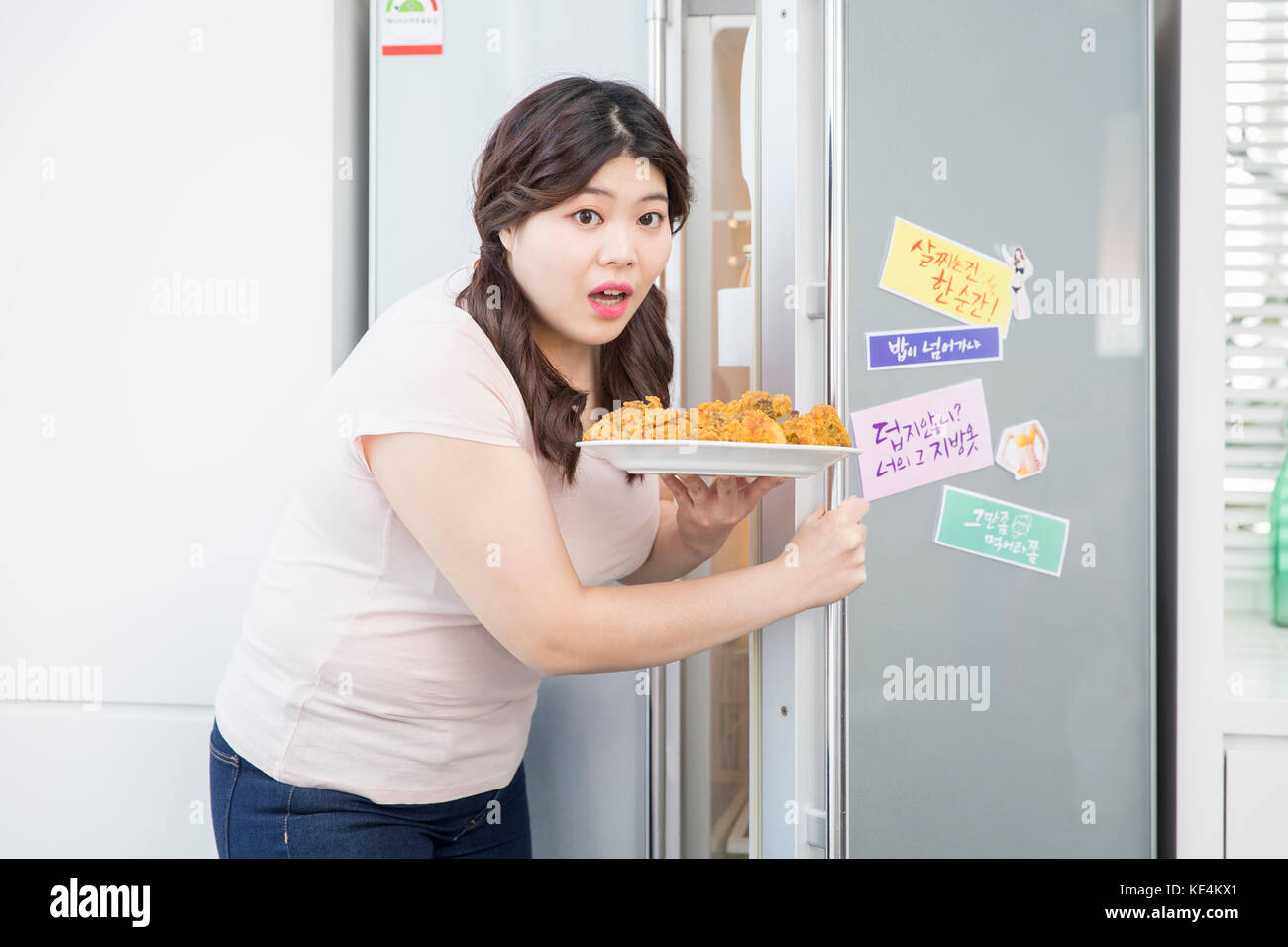Young fat woman taking fast food out of refrigerator Stock Photo - Alamy