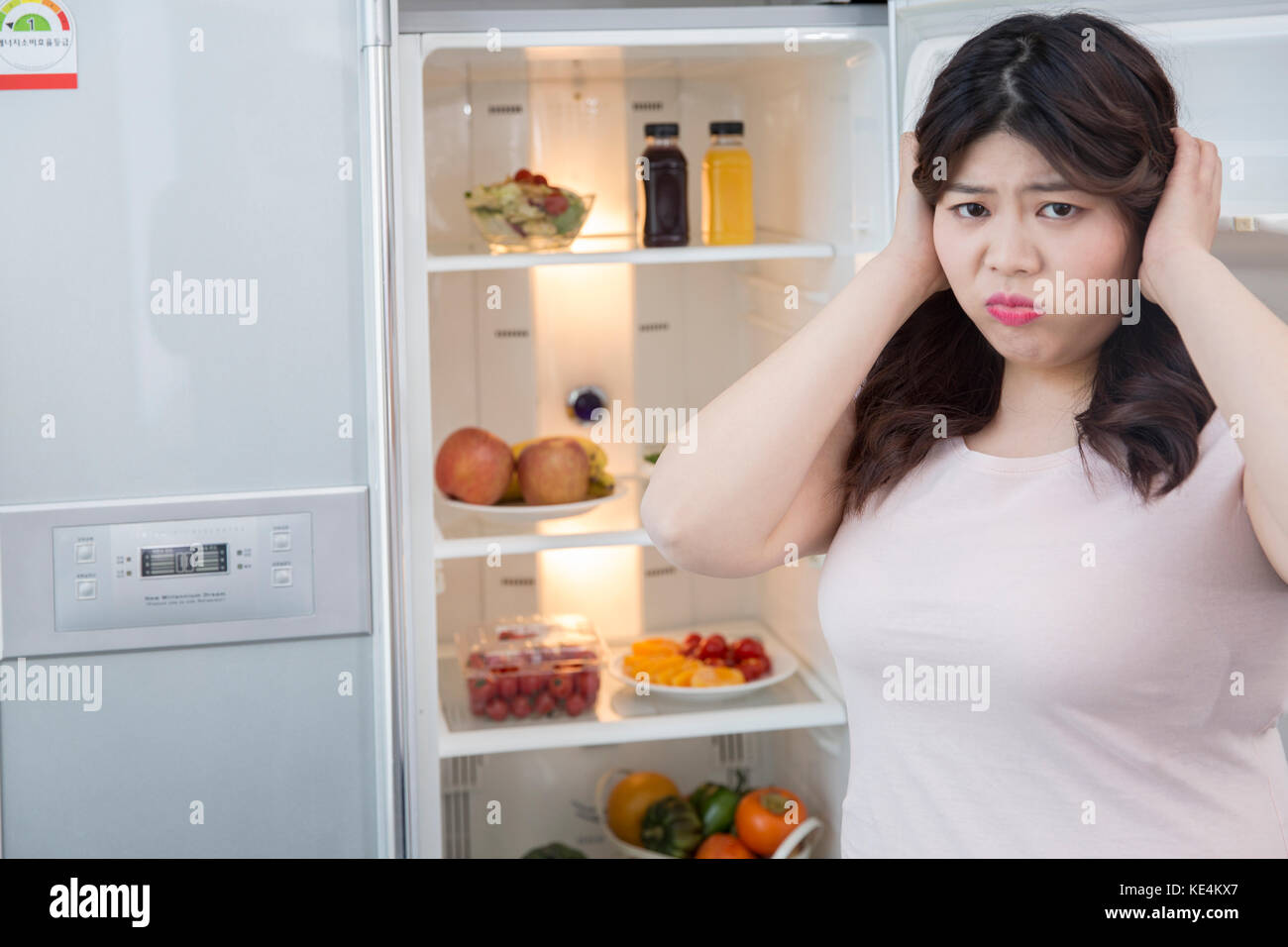 Portrait of young stressful fat woman at refrigerator Stock Photo - Alamy