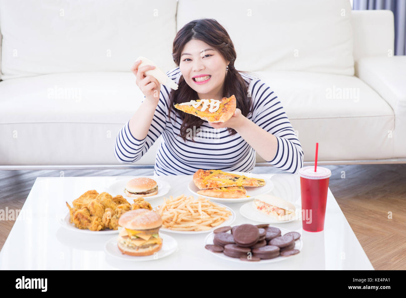 Portrait of young smiling fat woman eating fast-food and sweets Stock ...