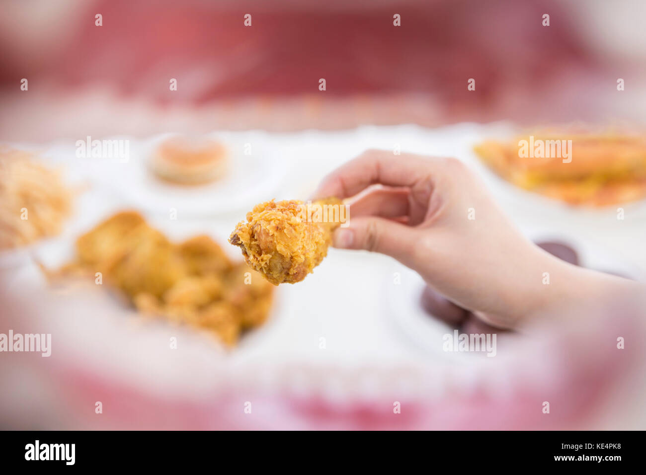 Hand holding fast-food served on a table Stock Photo - Alamy
