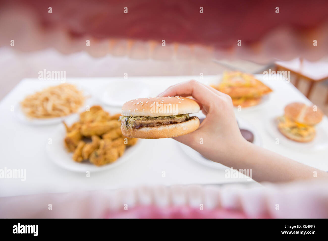 Hand holding fast-food served on a table Stock Photo - Alamy