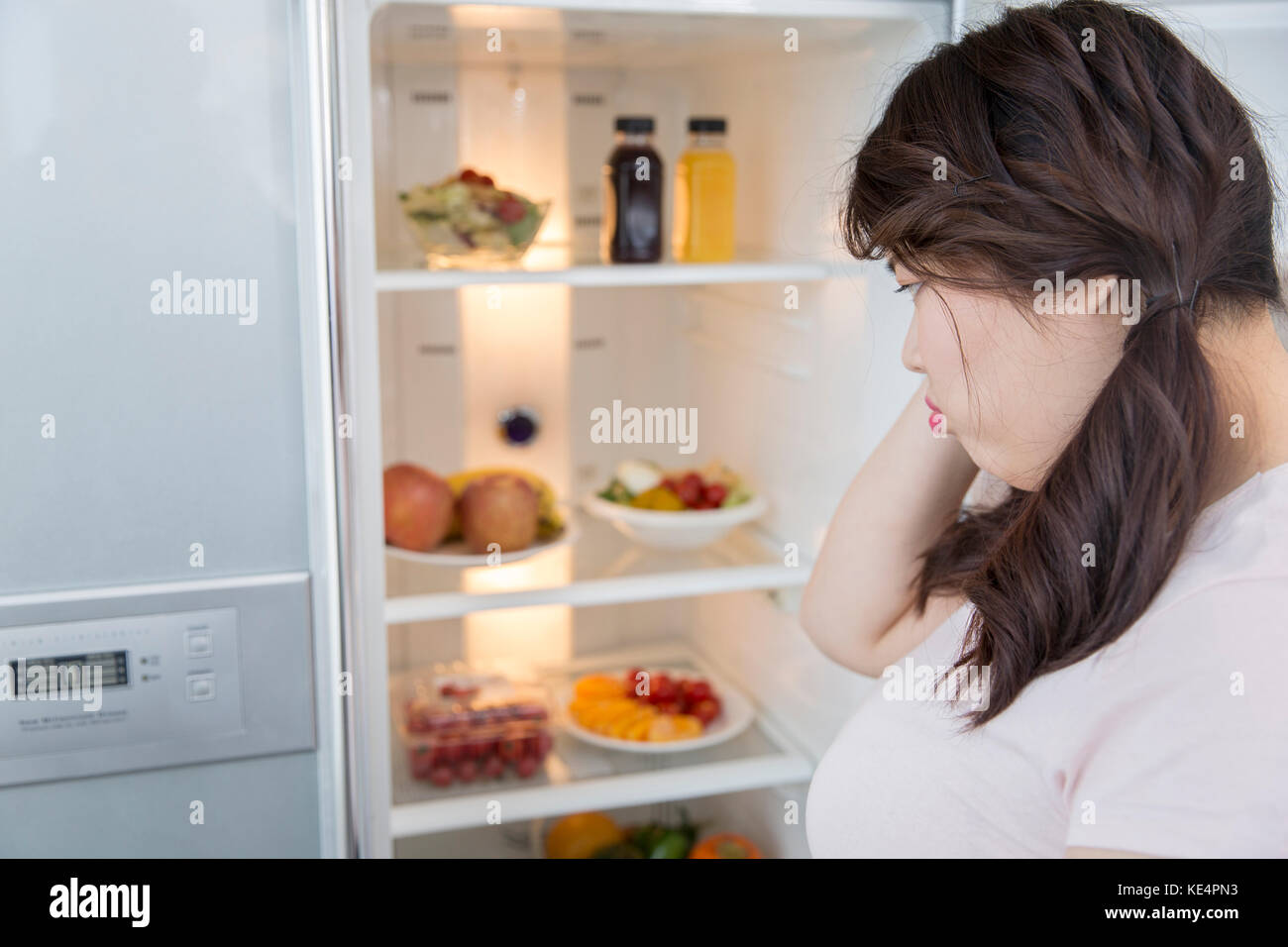Side view portrait of young fat woman looking in refrigerator Stock ...