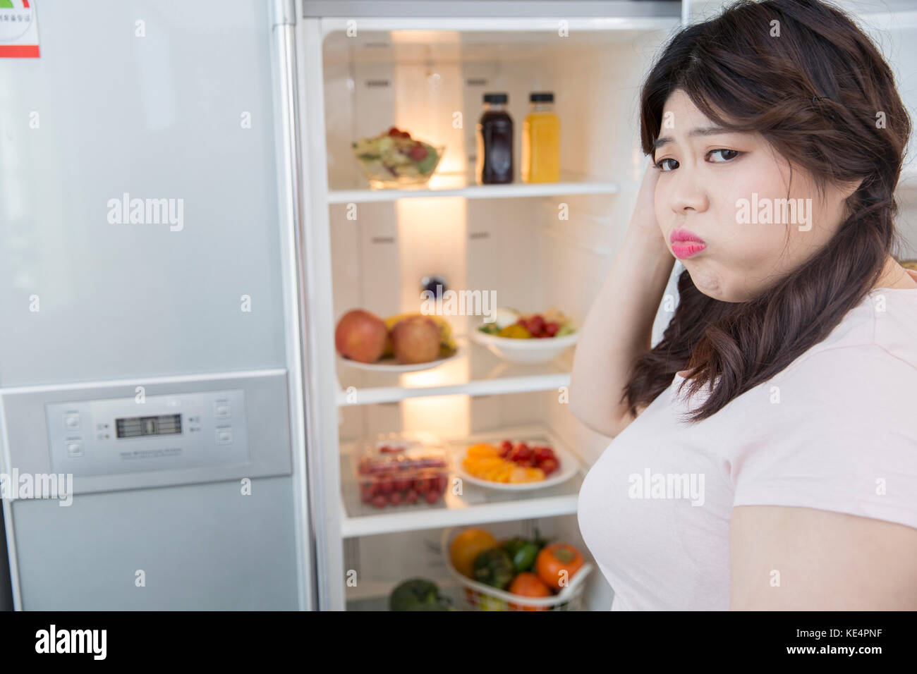 Side view portrait of stressful fat woman at refrigerator Stock Photo ...