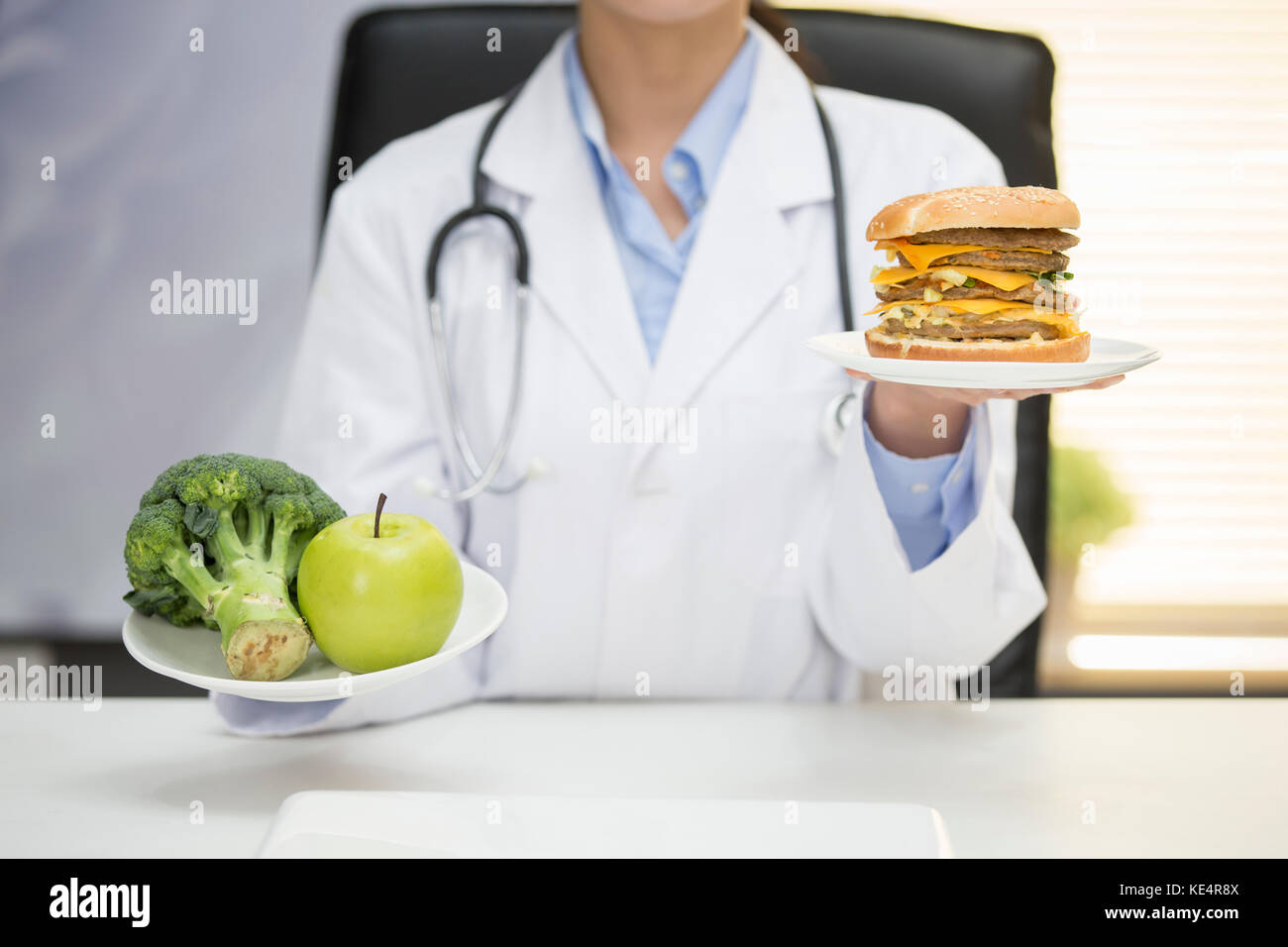 Portrait of female doctor holding fruit, vegetable and fast-food Stock ...