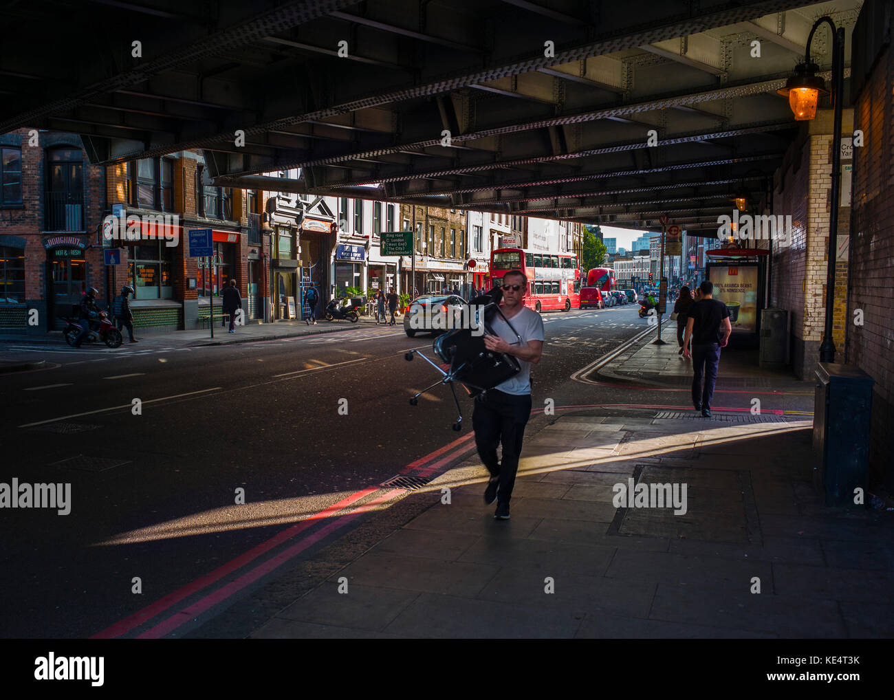 Man carrying office chair under bridge in city hi-res stock photography ...