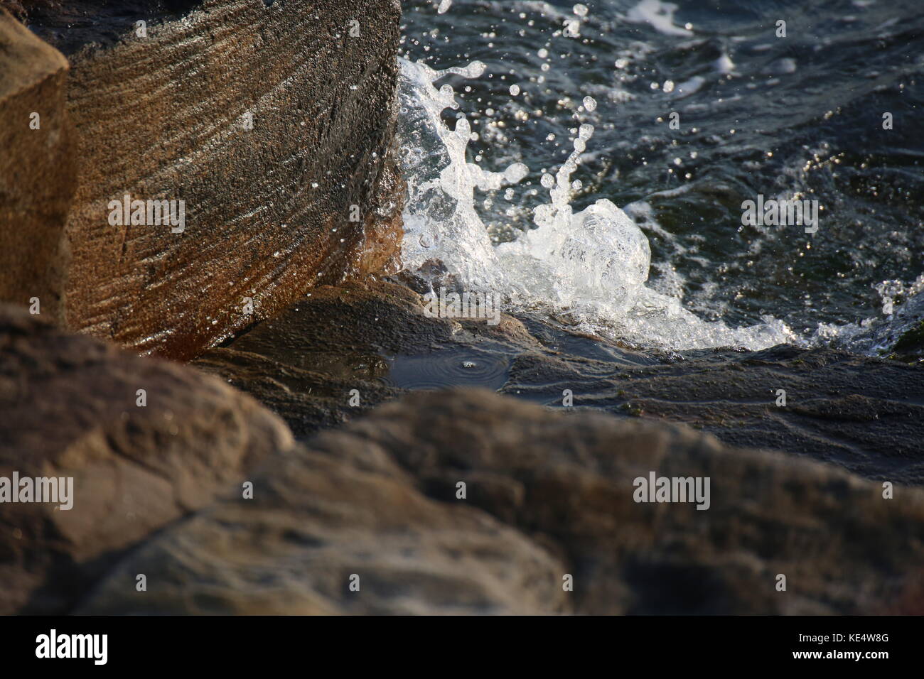 Water splashing against rock Stock Photo - Alamy