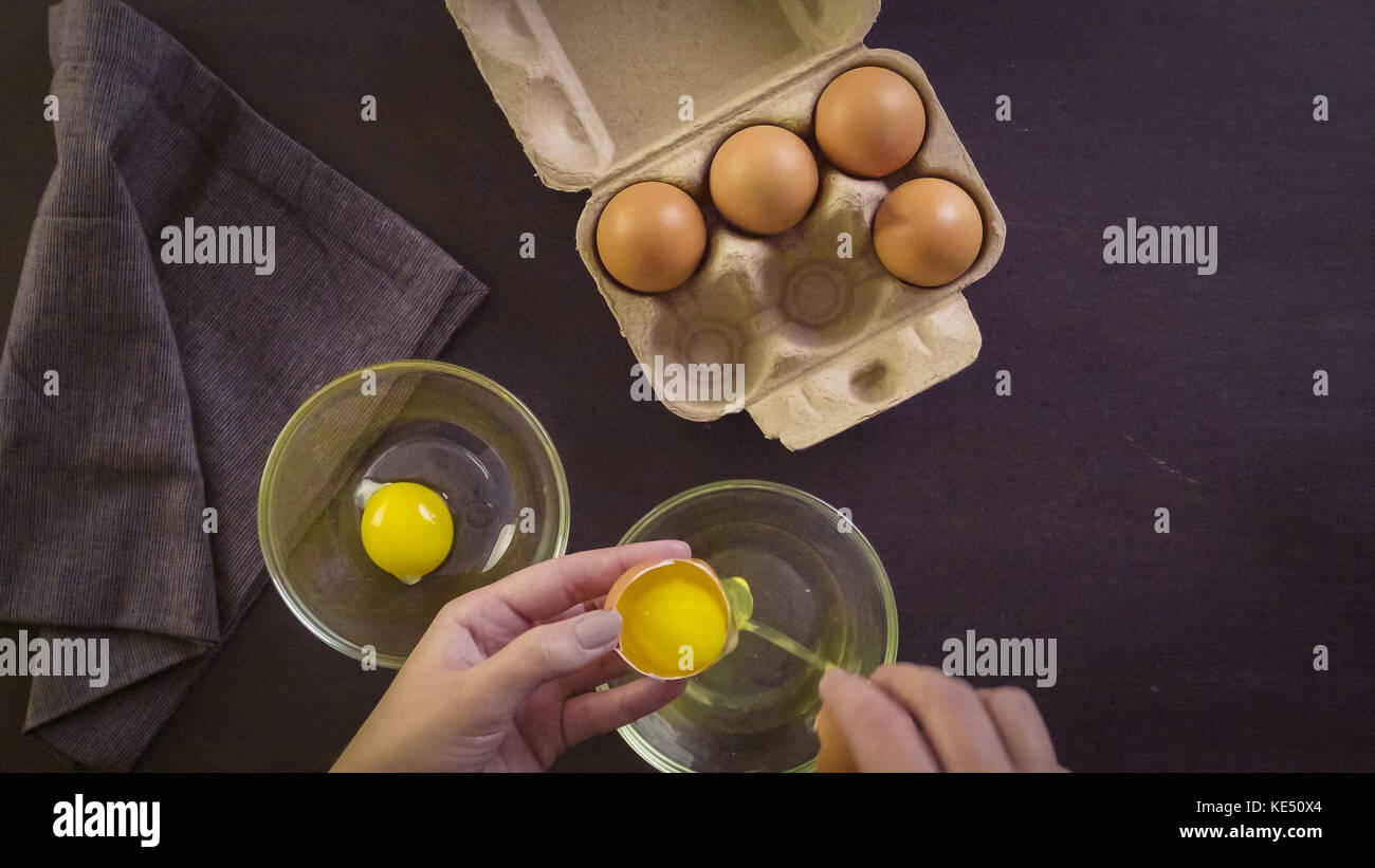 Step by step. Breaking large brown eggs into glass bowl Stock Photo - Alamy