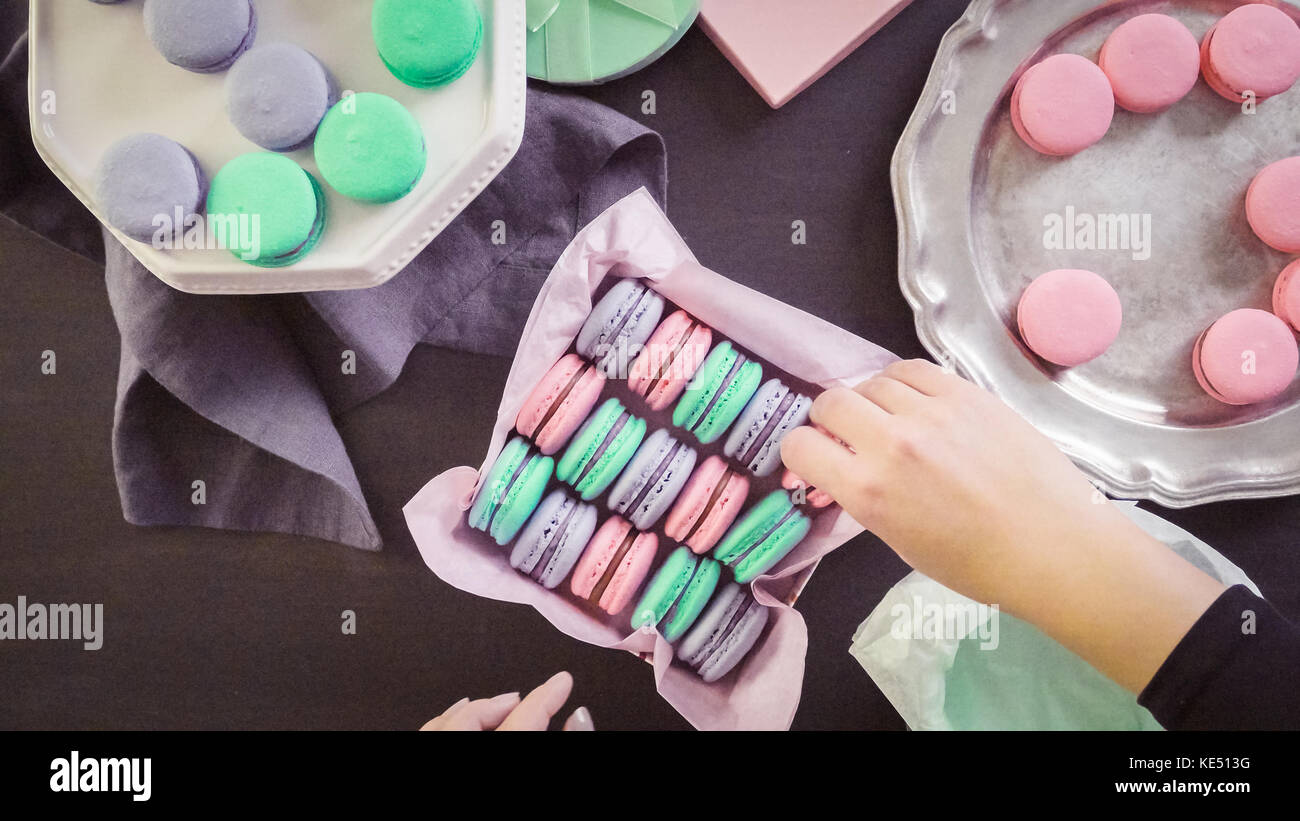 Step by step. Packaging french macarons into gift boxes Stock Photo - Alamy