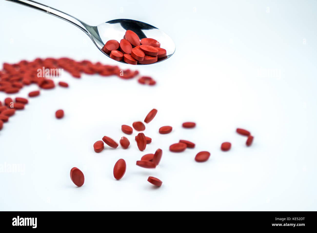 Iron tablets in spoon isolated on white background with copy space for ...