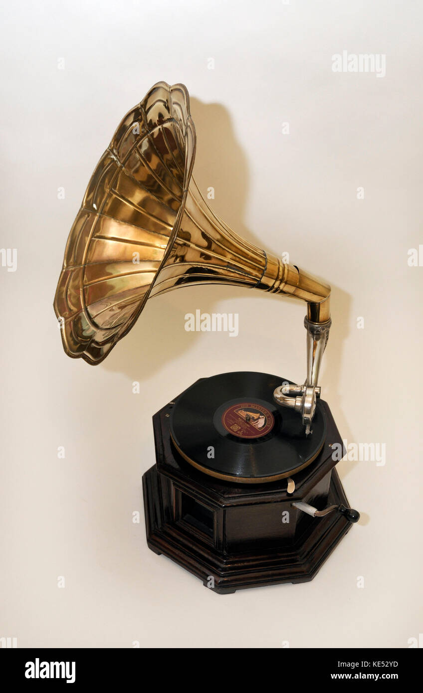 Early gramophone with large brass horn on round wooden base ...