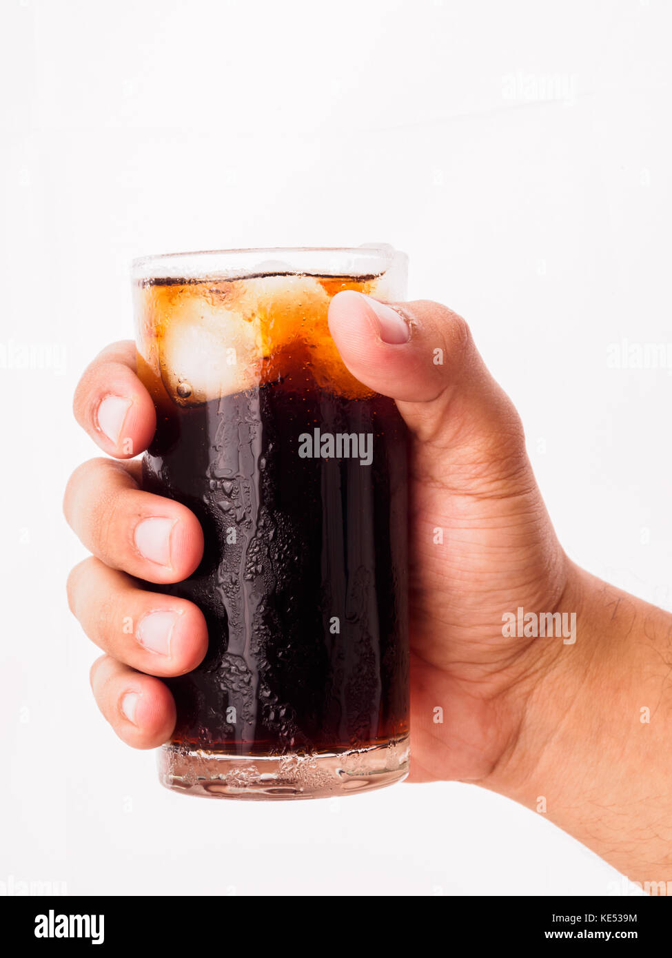 hand holding cola in glass with ice Stock Photo - Alamy