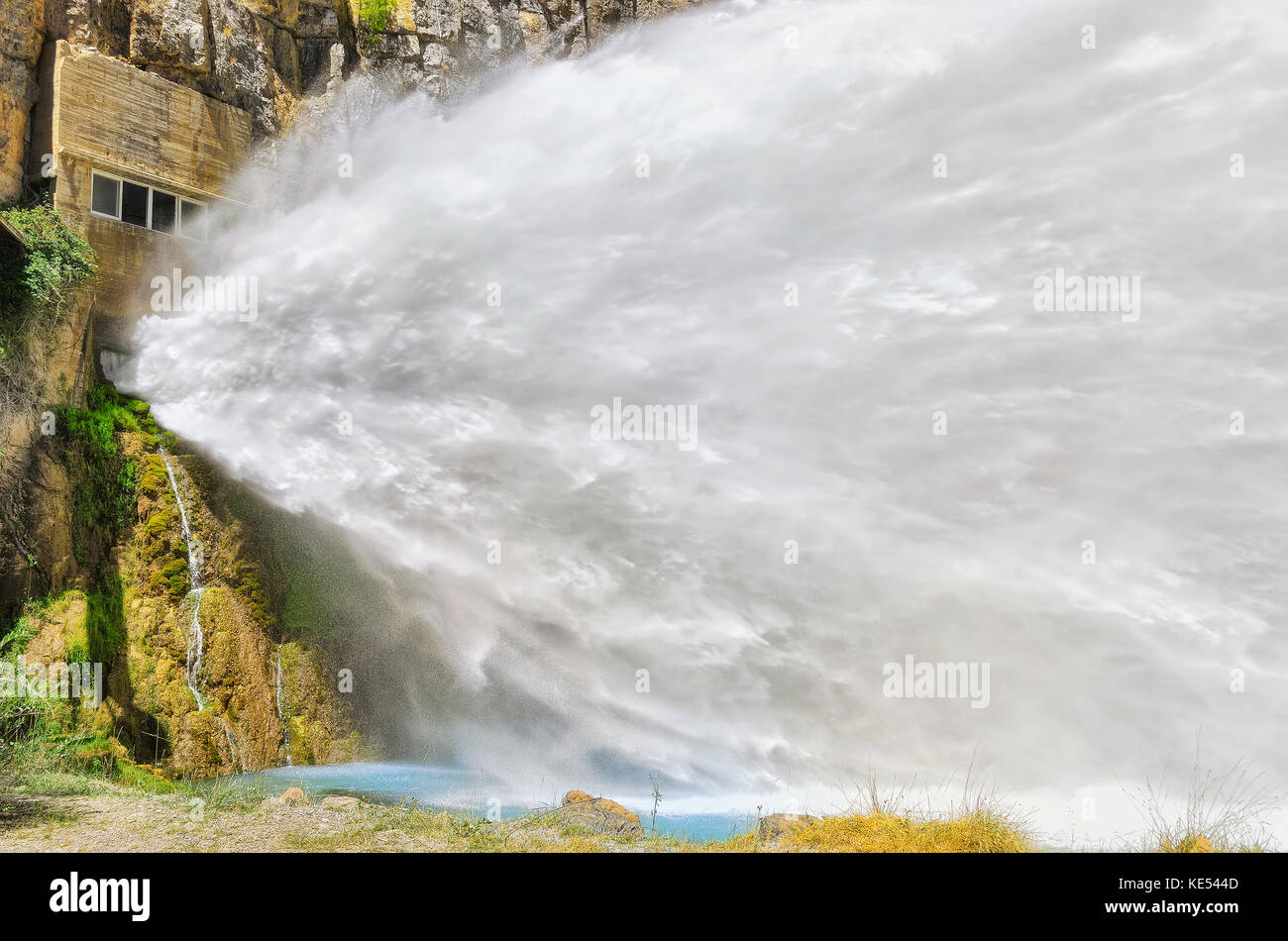 Artificial big waterfall formed by the spillway of hydroelectric dam ...