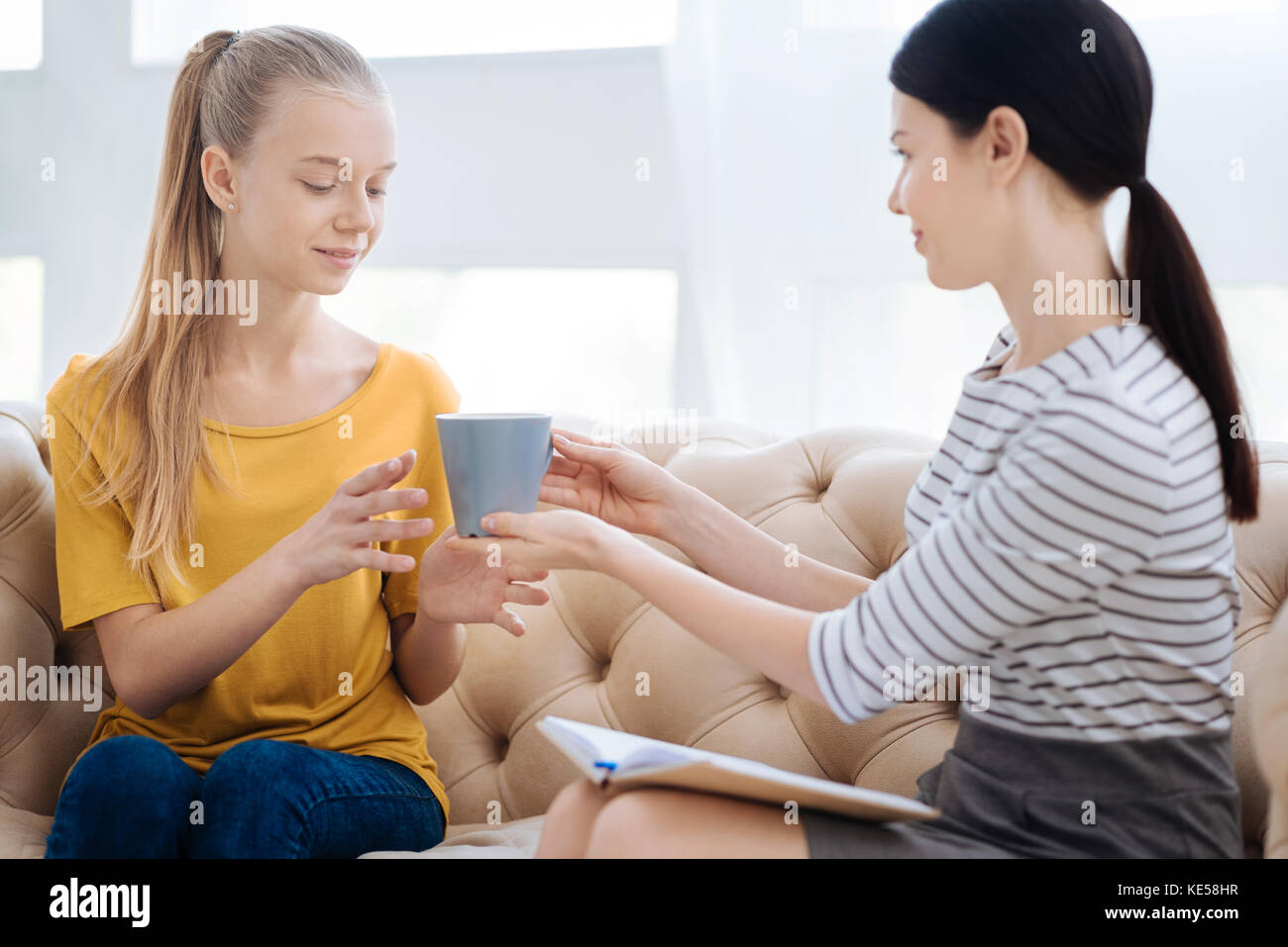 Positive young woman taking tea Stock Photo - Alamy