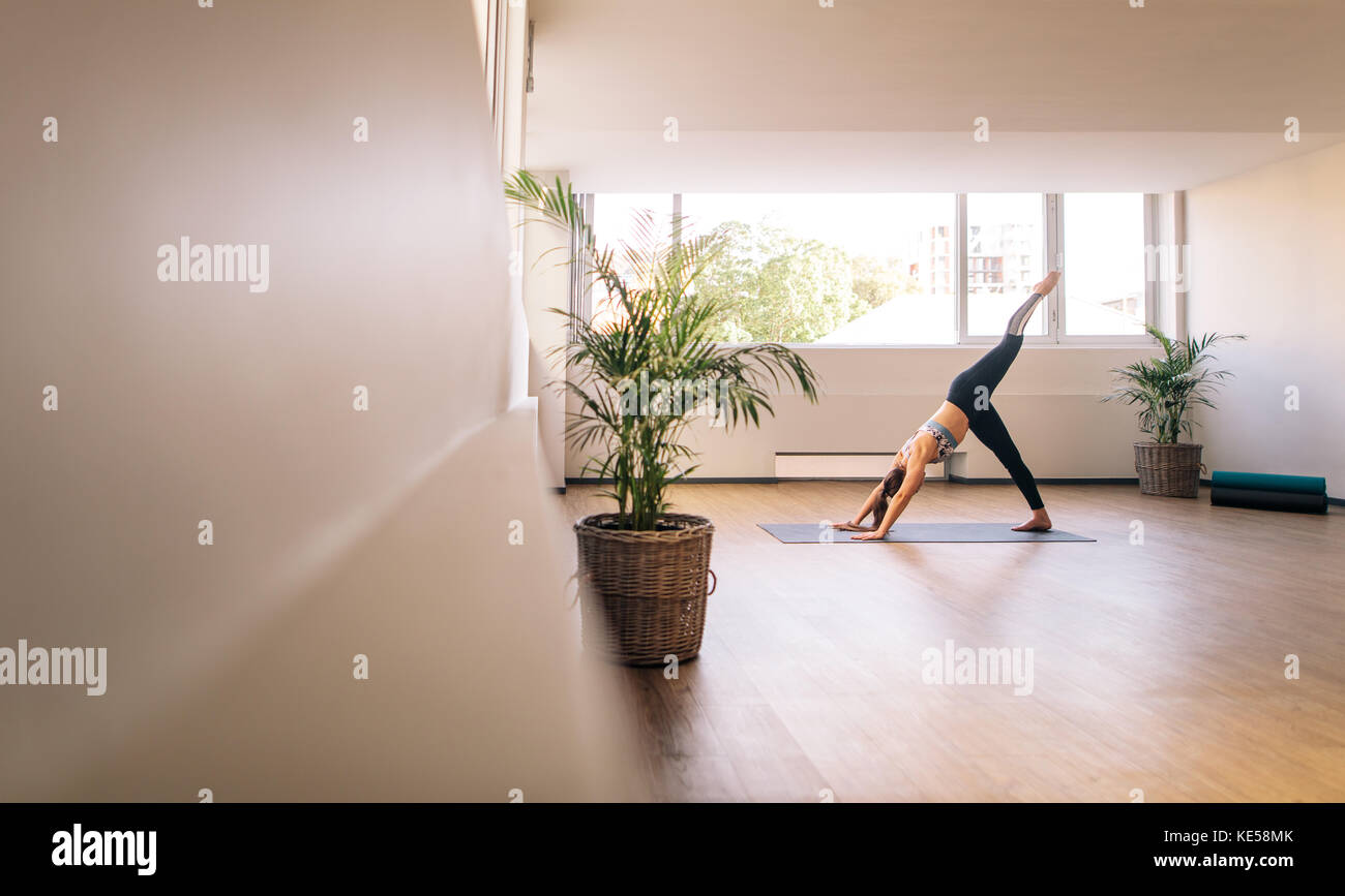 fitness woman practising yoga indoors. Female doing forward bend ...