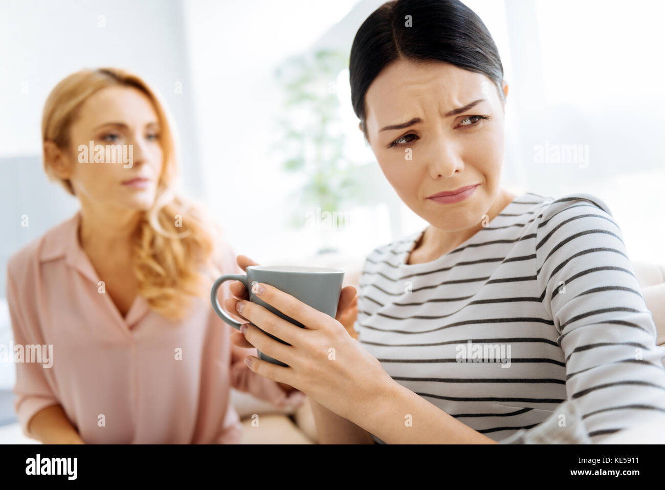 Moody upset woman drinking tea Stock Photo - Alamy