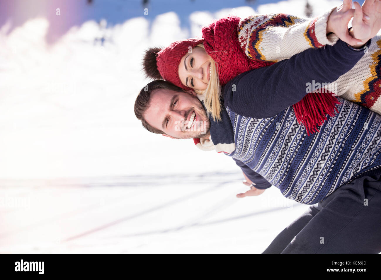 Man holding girlfriend on his back at the top of mountain Stock Photo ...