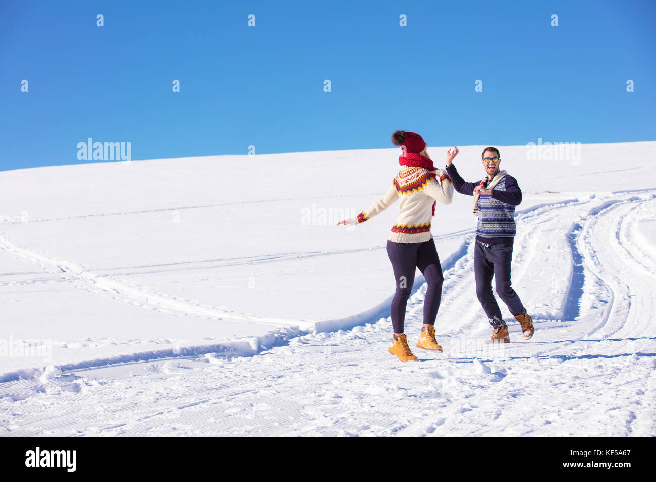 Carefree happy young couple having fun together in snow Stock Photo - Alamy