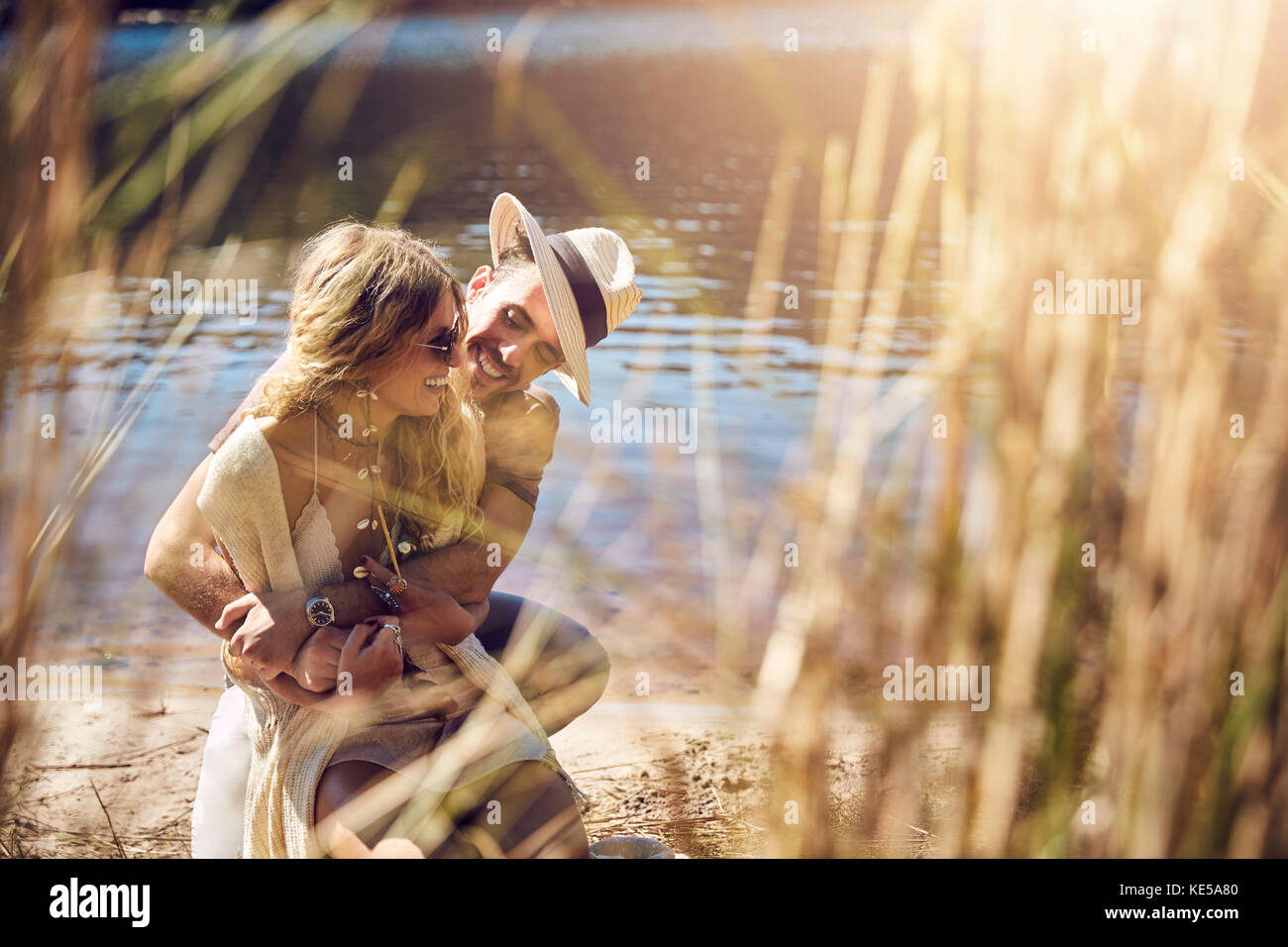 Affectionate young couple hugging at sunny summer riverside Stock Photo ...