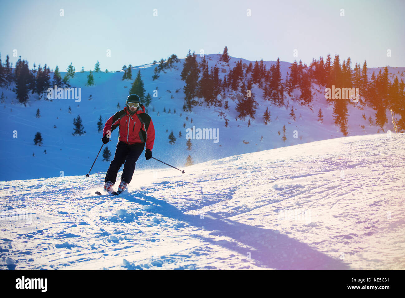 Skier skiing downhill in high mountains against sunset Stock Photo - Alamy