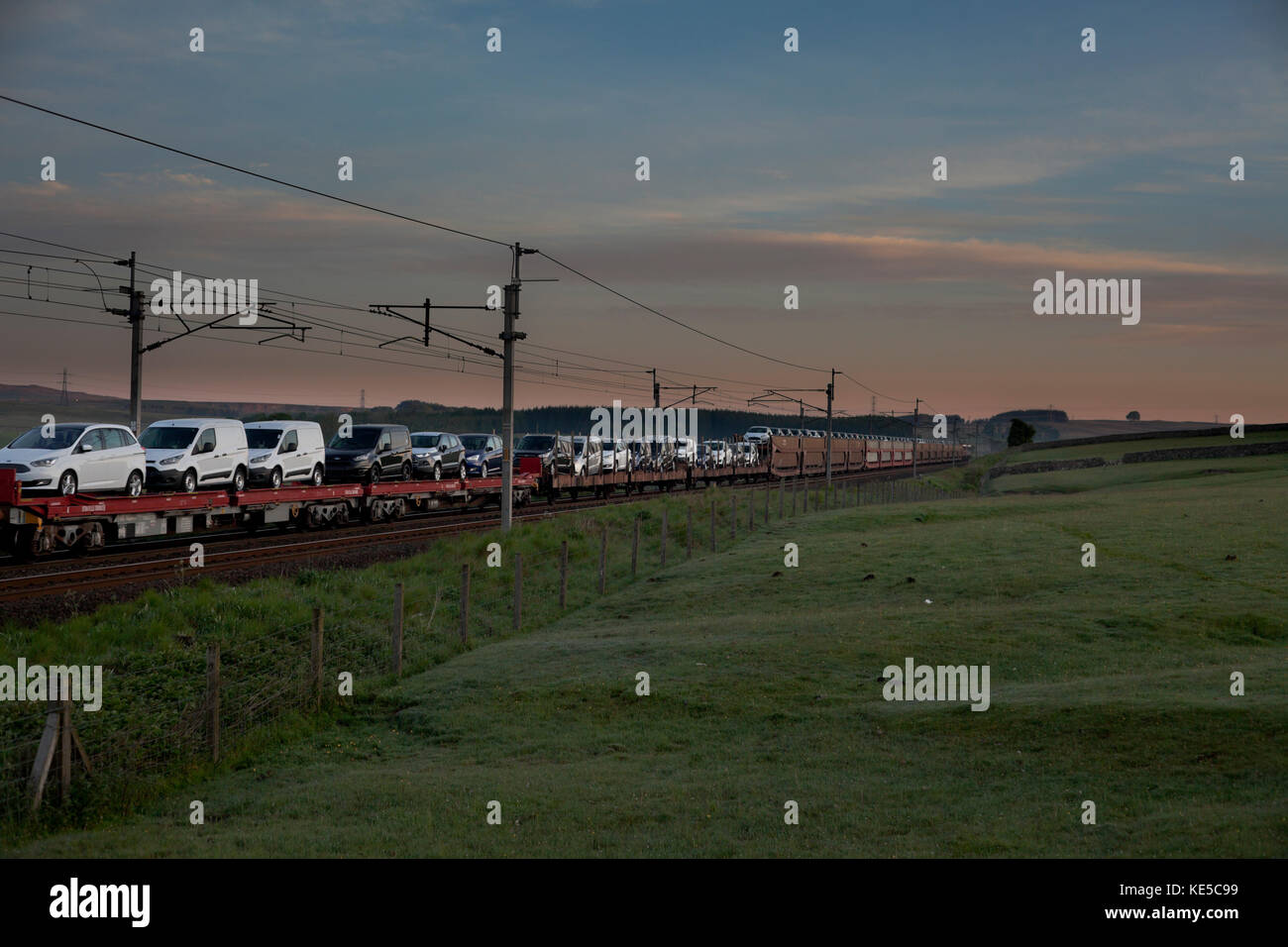 A DB Cargo freight train carrying new Ford motor vehicles passes ...