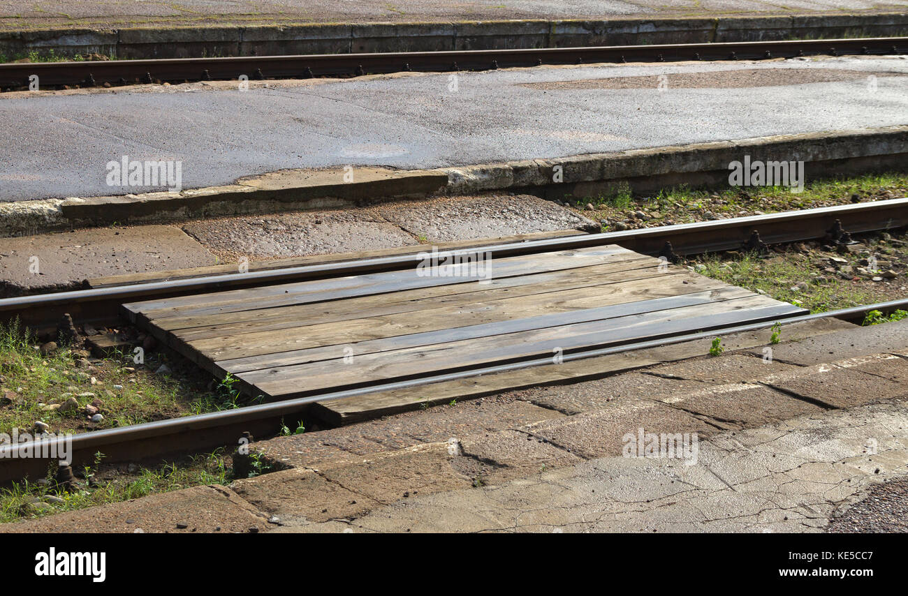 Old wet railway track, crossing over the rails Stock Photo - Alamy