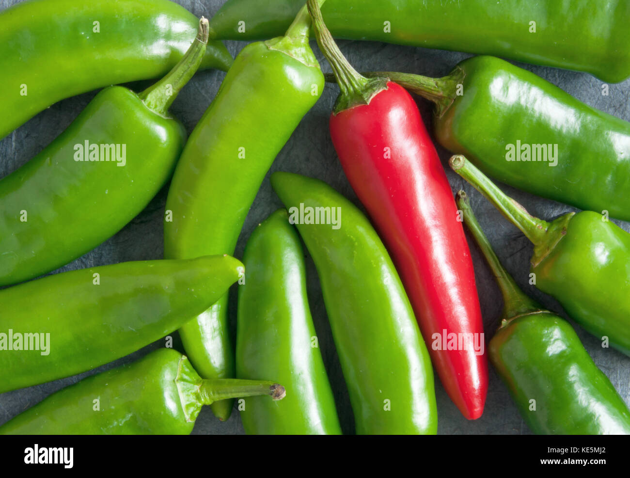 Red pepper amongst many green chillis Stock Photo - Alamy