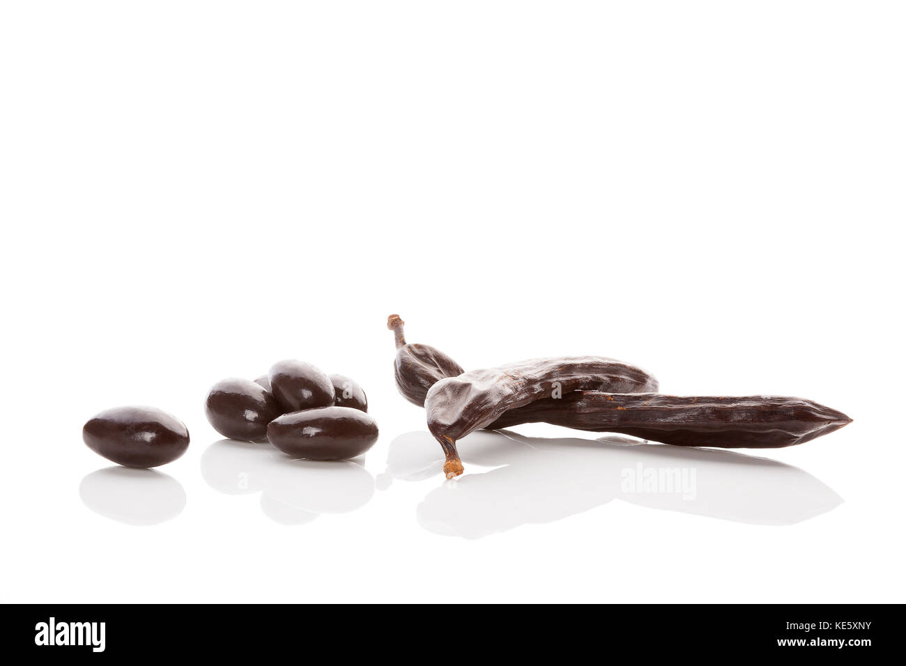 Carob pod and sweets isolated on white background. Healthy sweets ...