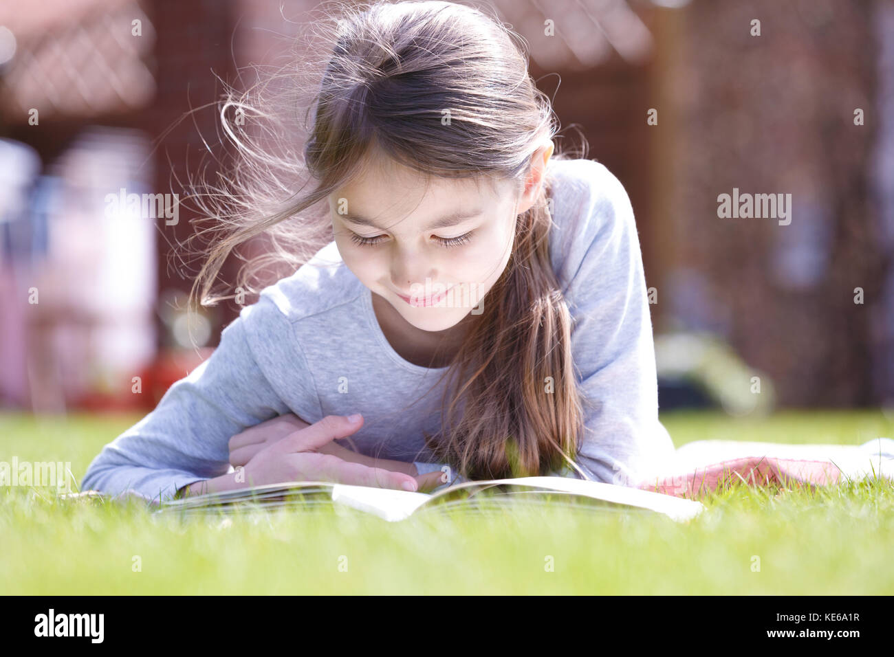A girl reading book on a green meadow Stock Photo - Alamy
