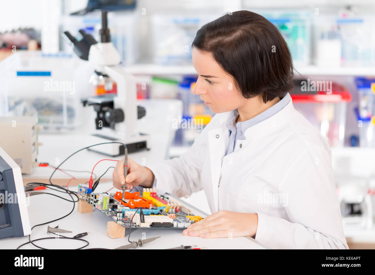 Female laboratory assistant Repairs PCB module for CNC robotics ...