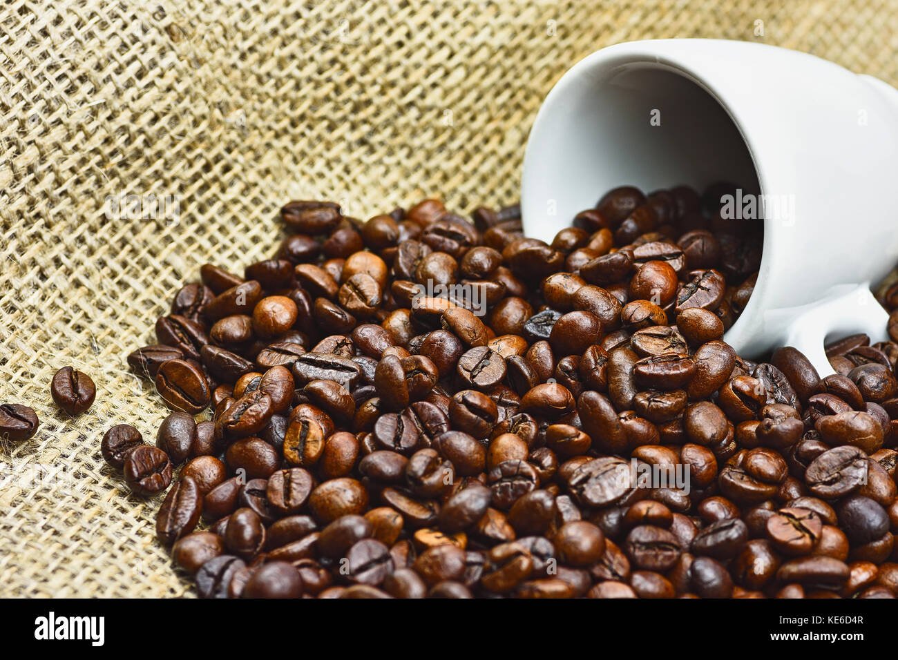 Close-up photo of grains of roasted black coffee with white porcelain ...