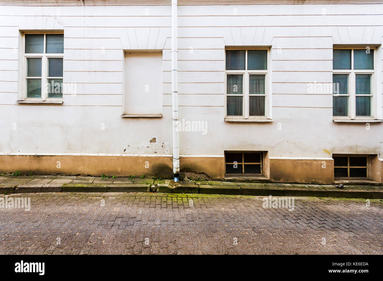 Old white weathered street wall with some windows Stock Photo - Alamy