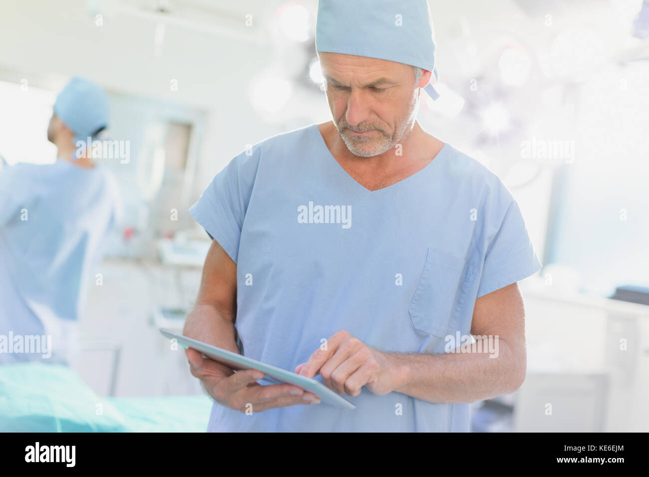 Male surgeon using digital tablet in operating room Stock Photo - Alamy