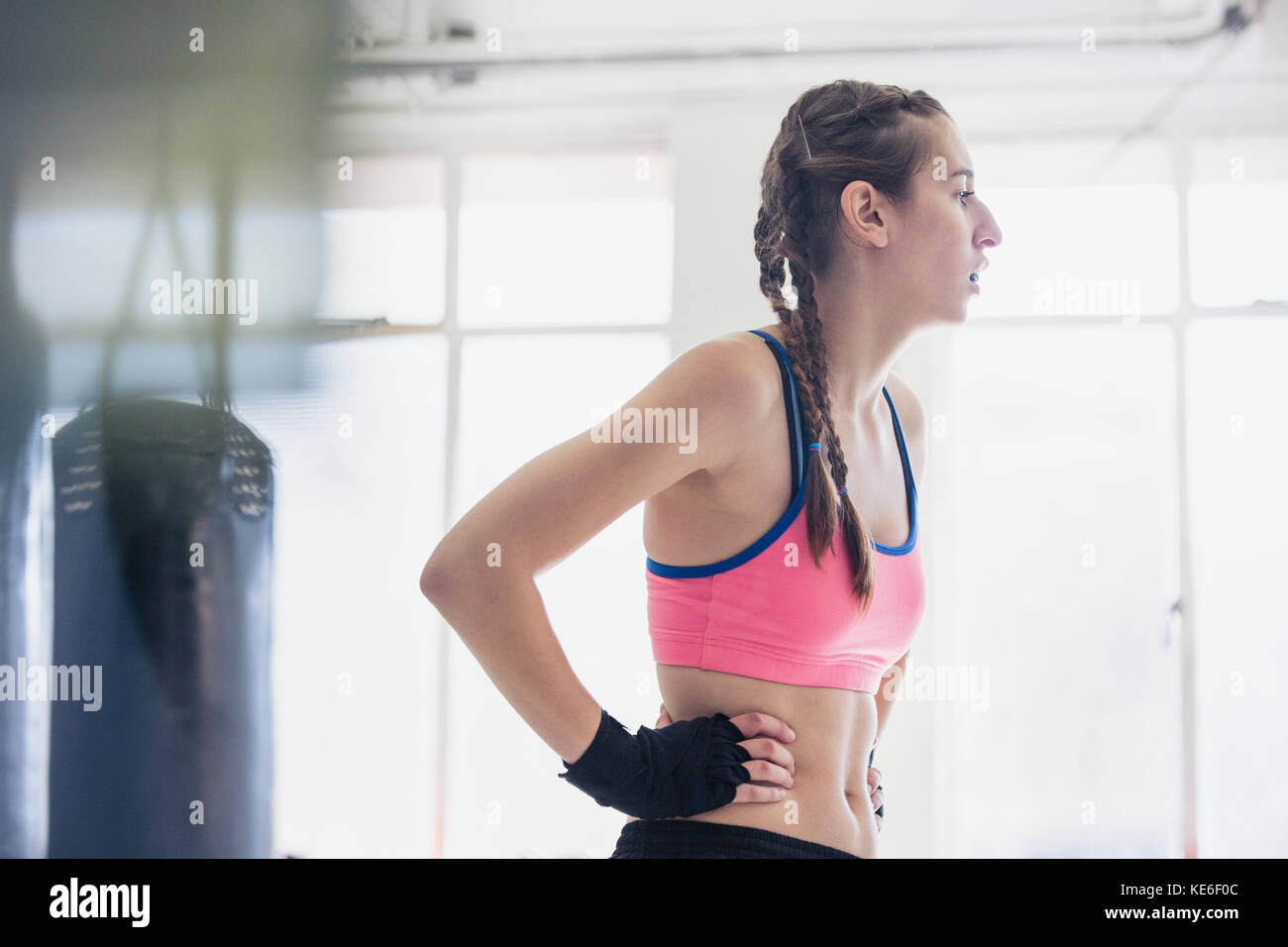 Tired young woman working out, resting with hands on hips in gym Stock ...