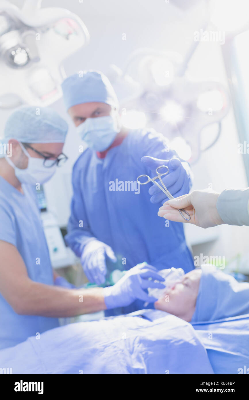 Surgeon reaching for surgical scissors in operating room Stock Photo ...