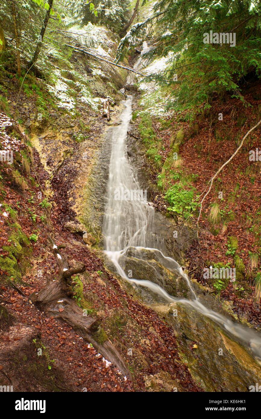Water spray below small waterfall on mountain stream, water is falling ...